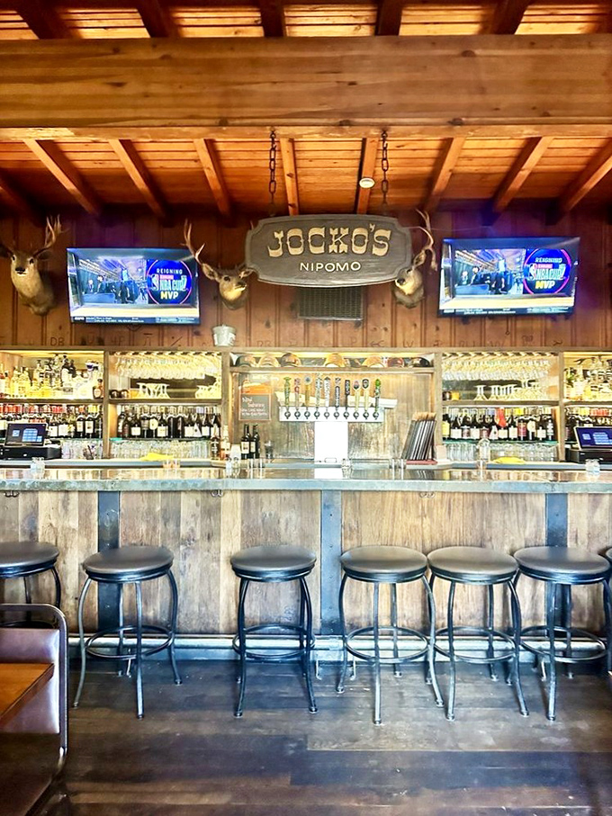 The rustic bar area where cold drinks flow and deer heads oversee conversations about the day's adventures.