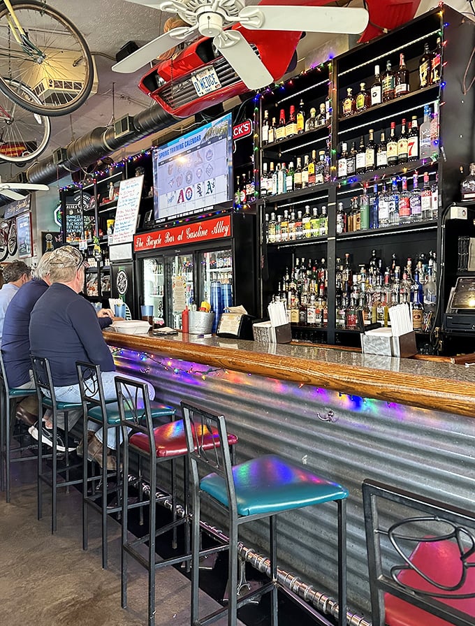 The bar at Gasoline Alley isn't just stocked&mdash;it's a liquid library of possibilities. Colorful lights add to the festive atmosphere of culinary celebration.