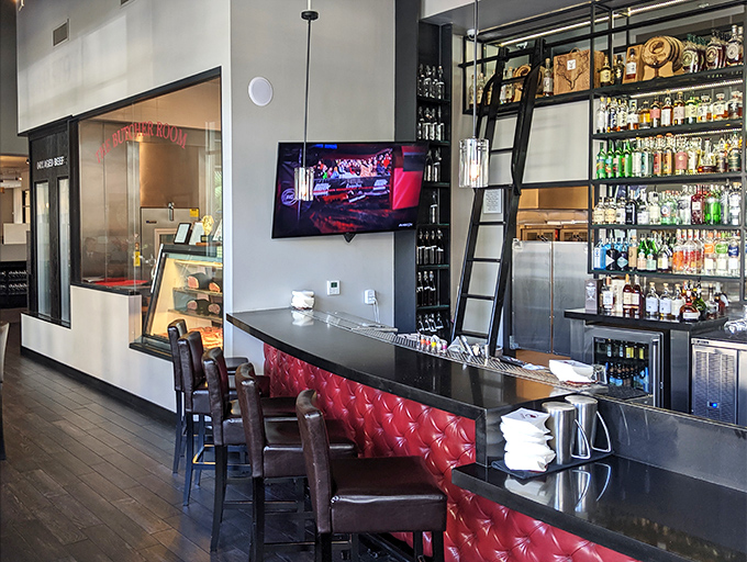 The bar beckons with bottles climbing skyward on library ladders, promising liquid courage before you tackle that 32-ounce porterhouse.