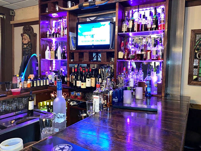 A bar stocked for serious business, illuminated like a shrine to libations. The purple glow isn't just ambiance—it's an invitation.