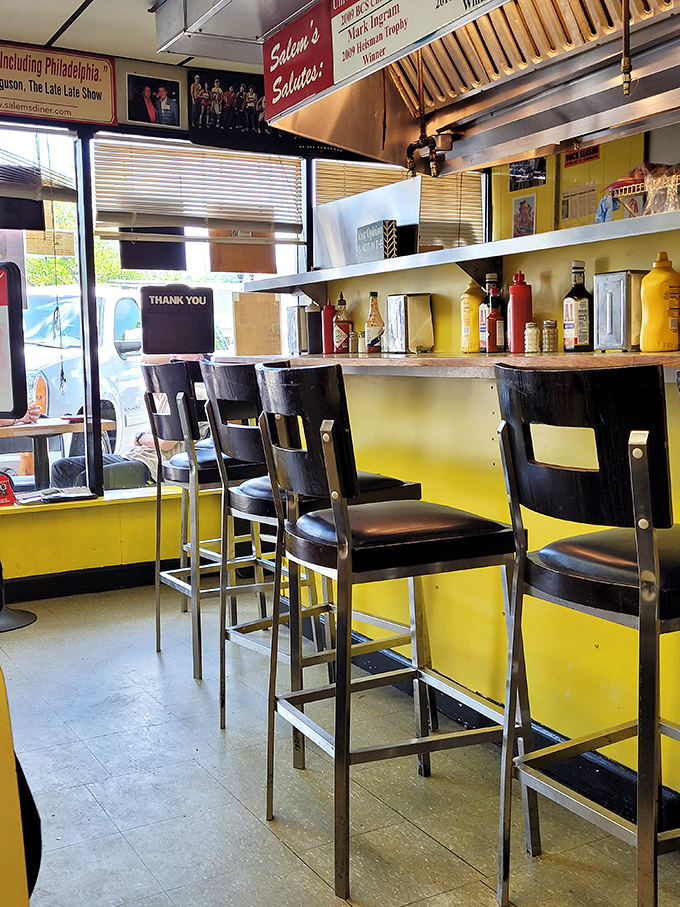 Empty stools that won't stay that way for long. The yellow counter gleams like a runway, ready for plates to make their grand entrance from kitchen to customer.