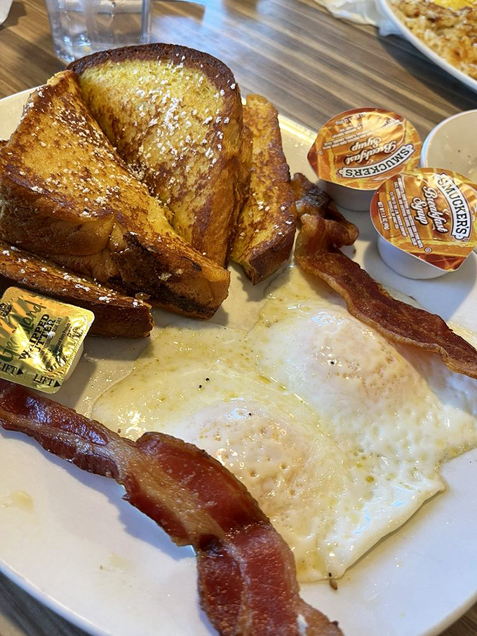 Breakfast of champions: French toast that's achieved that magical golden hue, with eggs and bacon playing perfect supporting roles.