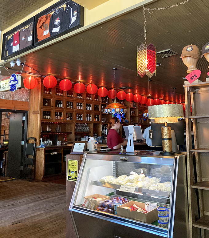 Behind the counter, Wisconsin's liquid heritage lines the shelves while cheerful red lanterns create the perfect mood lighting for serious cheese consumption.
