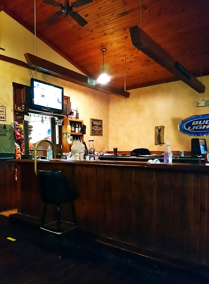 The bar area where locals gather to debate everything from fishing spots to football. Those ceiling beams have absorbed decades of laughter and tall tales.