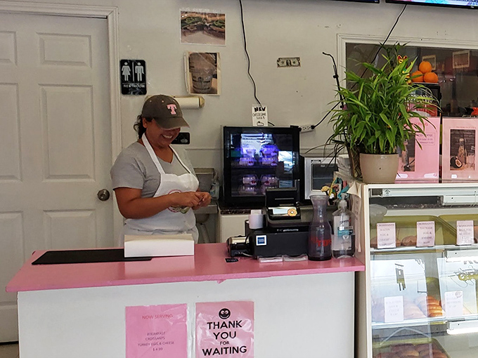 Behind the counter, where donut dreams become reality. The pink countertop adds a touch of whimsy to this serious business of breakfast.