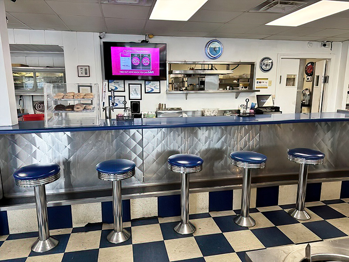 The counter seating offers front-row tickets to the culinary show, those classic blue stools having supported generations of satisfied customers.