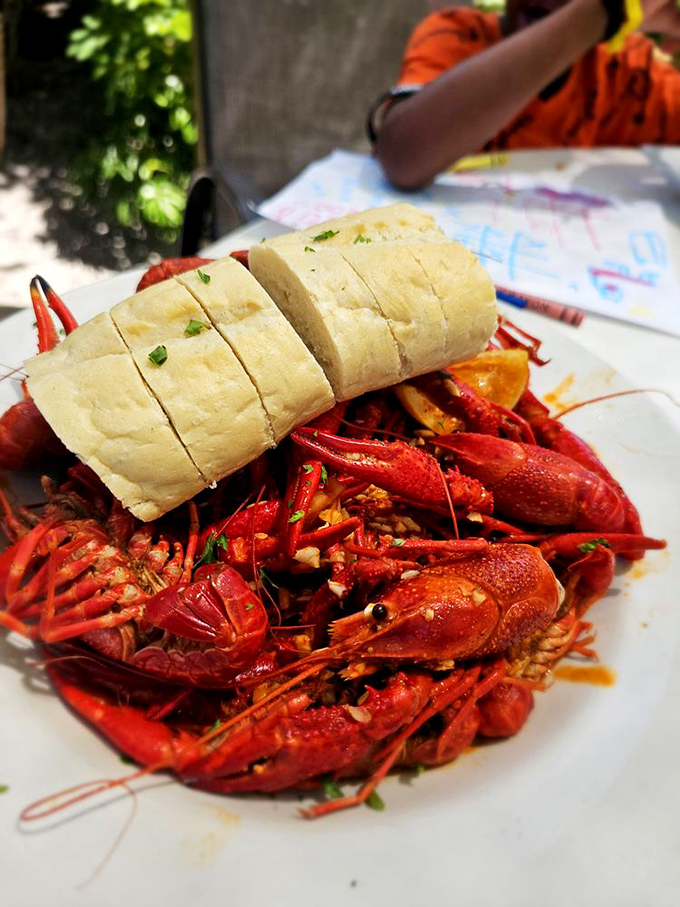 Crawfish so vividly red they look like they're blushing from all the attention, with crusty bread ready to soak up that garlicky, spicy goodness.