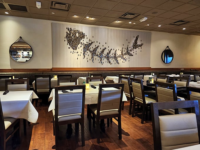 The dining area's elegant simplicity and artistic wall installation create an atmosphere where conversations flow as smoothly as the wine.