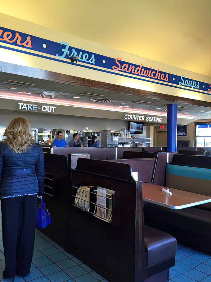 Counter seating and booths offer options for solo diners and groups alike. The "Fries &bull; Sandwiches &bull; Soups" banner is basically a roadmap to happiness. 