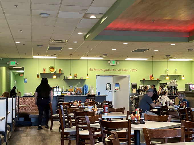 The green walls and colorful pendant lights create a morning sanctuary where coffee flows and breakfast prayers are answered.