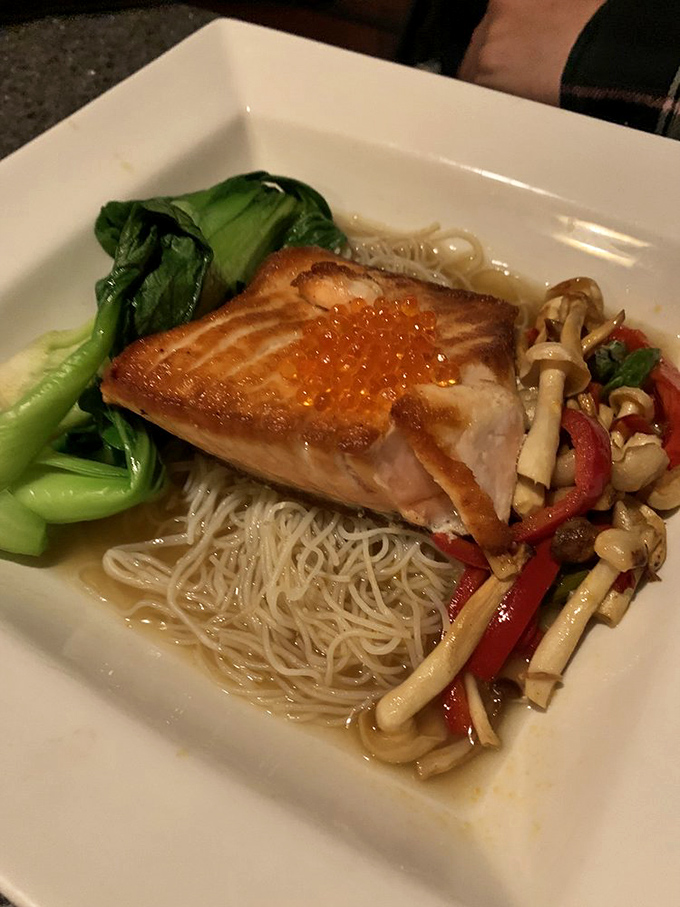 Salmon with skin so crispy it practically shatters, perched atop a nest of noodles that have soaked up all the right flavors.