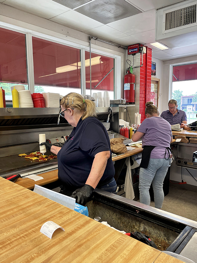 Behind the counter, the real magic happens—skilled hands performing the delicate dance of burger-flipping that no fancy culinary school teaches.