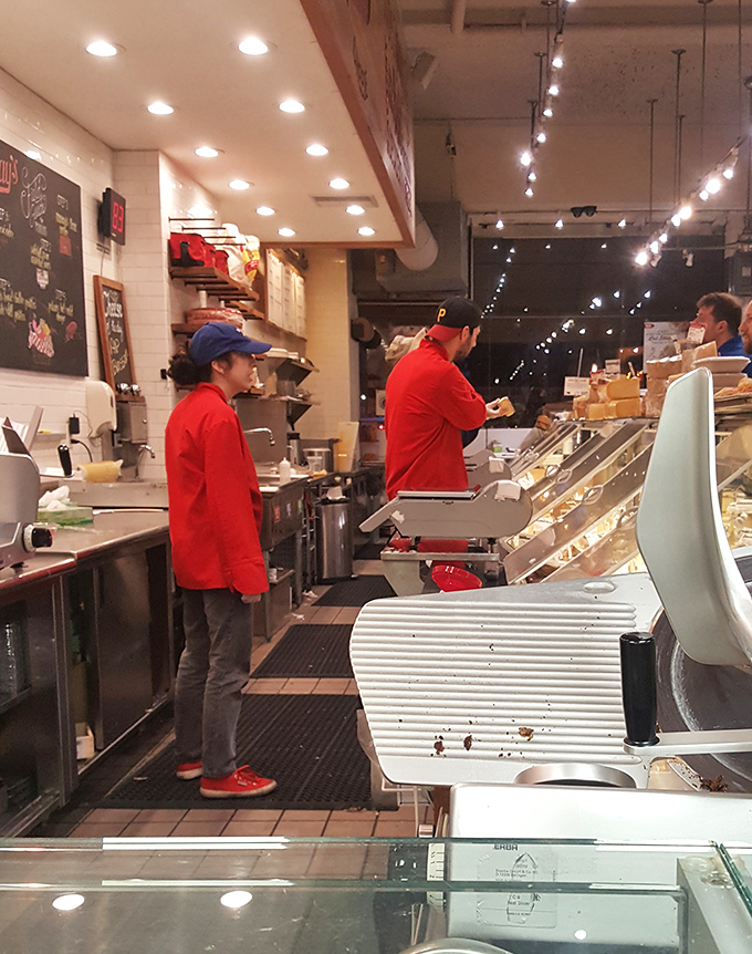 The red-jacketed cheese professionals stand ready to guide your dairy journey, like Sherpas of the cheese world, expertly navigating the terrain of taste.