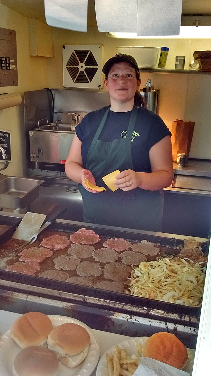 The alchemy happens here—fresh patties sizzling on a well-seasoned flat top, with cheese slices waiting for their moment of glory.