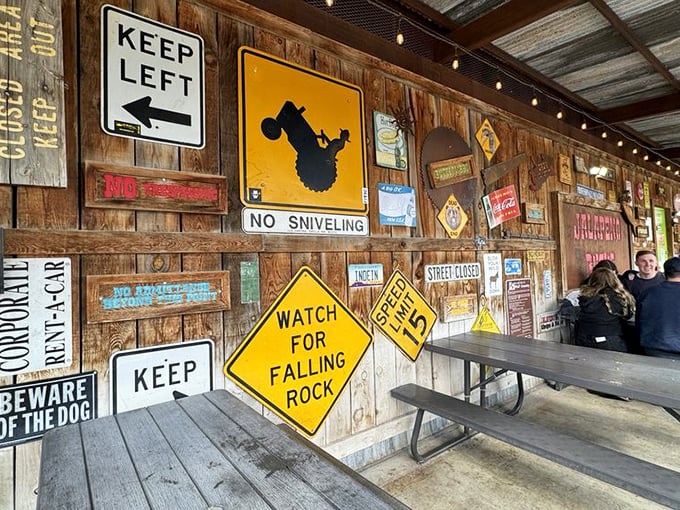 Warning signs and cowboy motifs create the perfect dining backdrop. Nothing says "authentic Southwestern experience" quite like this wall.