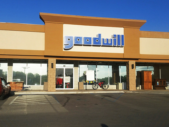 Goodwill's familiar blue logo stands out against warm beige tones. A community landmark for generations of treasure hunters.