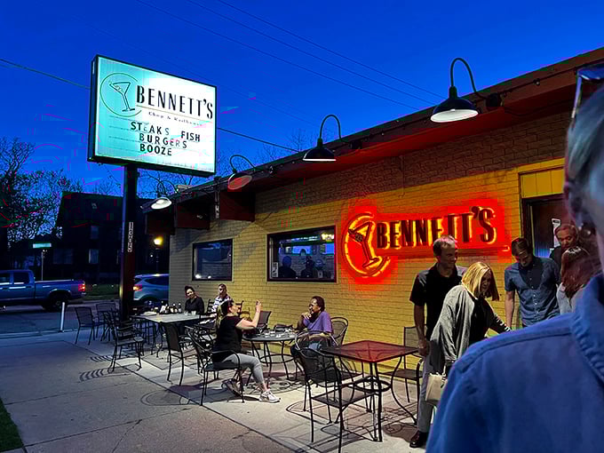 Bennett's outdoor seating area comes alive at night under the glow of their neon sign. Urban steak paradise awaits.