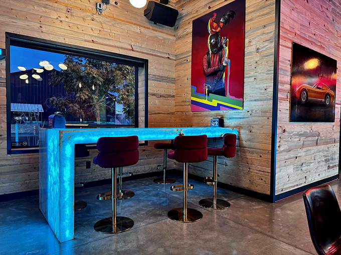 Blue-lit counters and plush red barstools create the perfect perch for chicken contemplation or post-spice recovery.