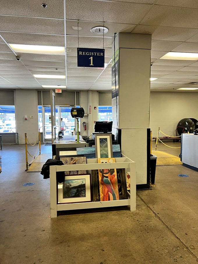 
The checkout area showcases framed artwork waiting for new walls to call home. One person's rejected landscape is another's perfect living room conversation piece!