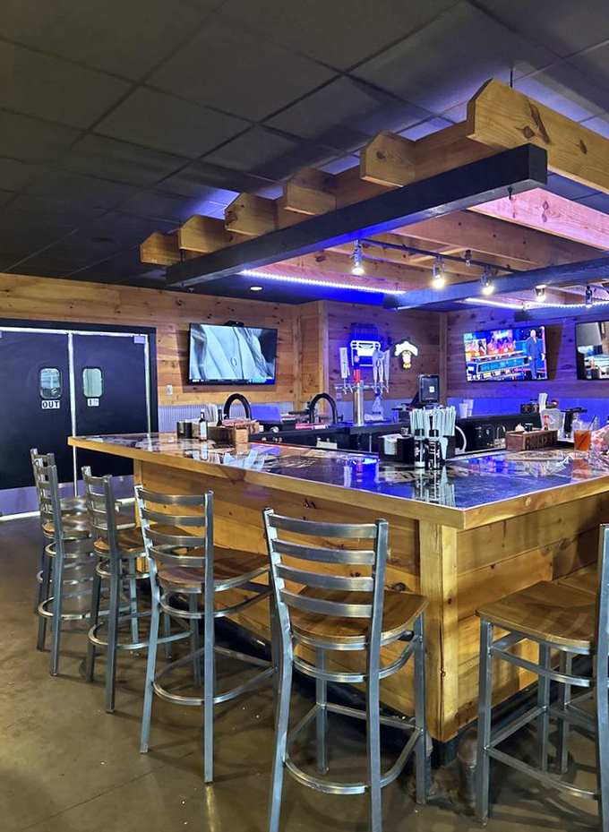 The bar area glows with blue lighting and wooden warmth, promising cold drinks and good conversation while you wait for your table.