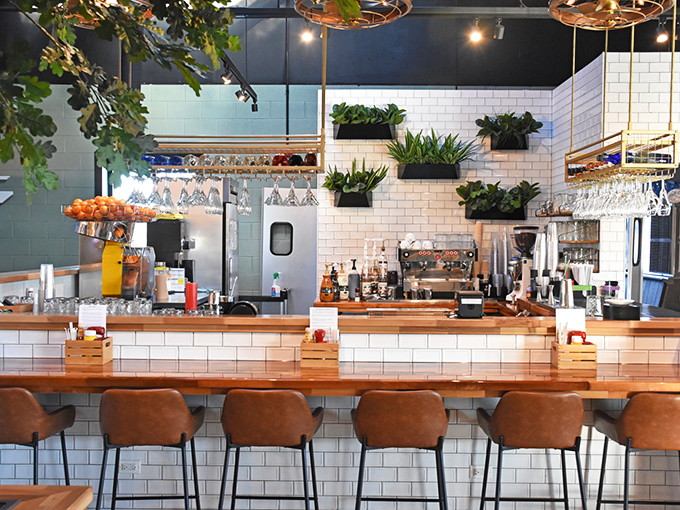 The bar area combines subway tile, warm wood, and hanging plants&mdash;like if your coolest friend designed a coffee shop after watching too much HGTV.