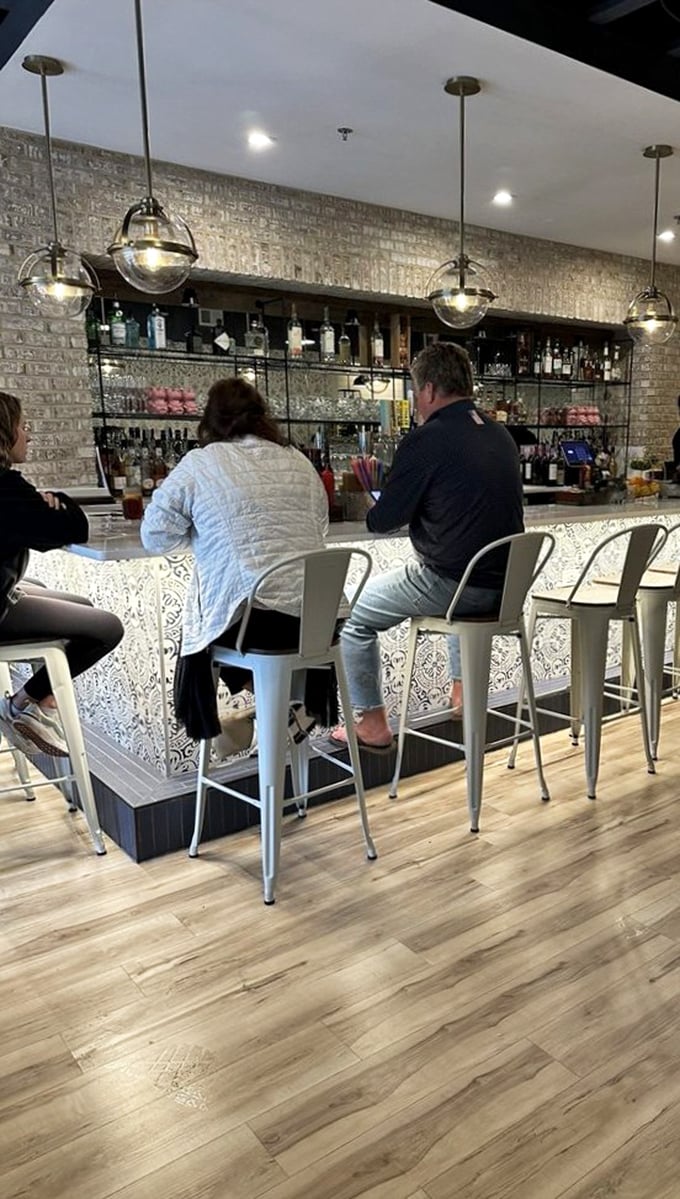 The bar where strangers become friends and decisions get deliciously difficult. Those globe lights aren't just illuminating the space—they're spotlighting your next great food memory.