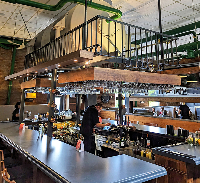 The bar area marries function and style, where mixologists craft cocktails beneath suspended glassware that catches the light.