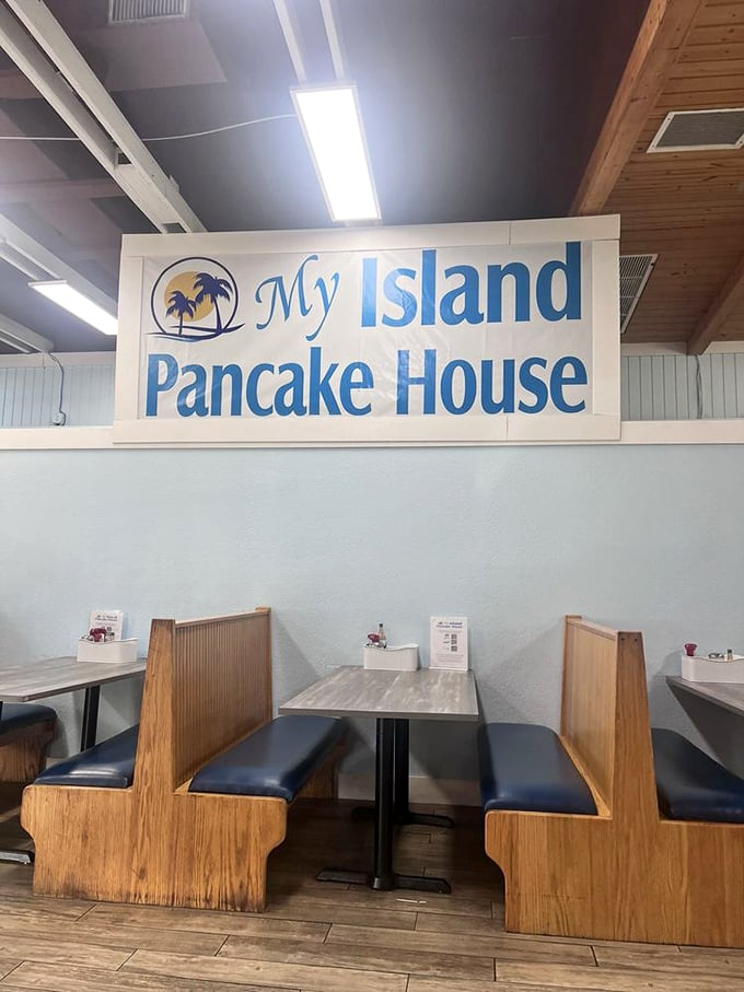 Classic diner booth seating under the watchful gaze of the restaurant's cheerful sign&mdash;where countless breakfast dreams have come true.