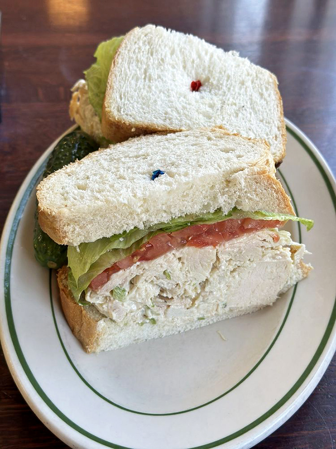 A chicken salad sandwich that refuses to be basic – fresh white bread, crisp lettuce, and enough filling to make you question everything about portion control.