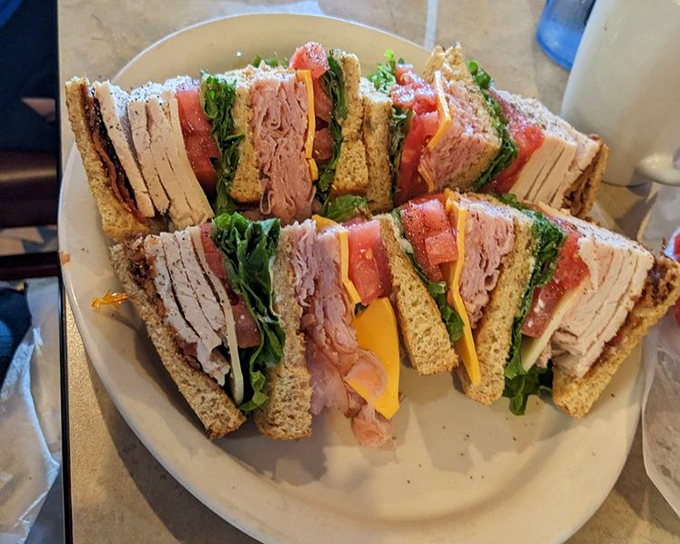 The club sandwich stands tall and proud, a skyscraper of freshness that makes lunch feel like an achievement worth celebrating.