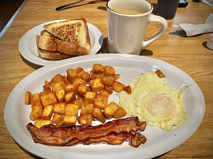The classic American breakfast trifecta: eggs, bacon, and toast, accompanied by the true hero &ndash; a mug of steaming coffee that promises consciousness.