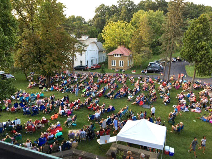 Community gatherings on the lawn where strangers become neighbors over shared blankets and summer concerts.