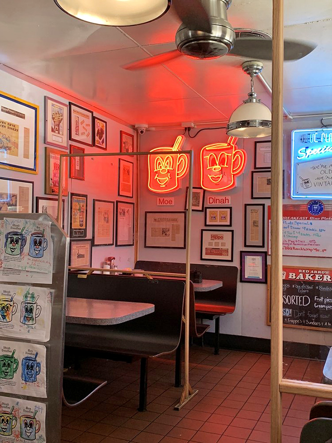 Neon coffee cups glow like beacons in this cozy corner booth, where countless conversations and confessions have unfolded over pancakes.