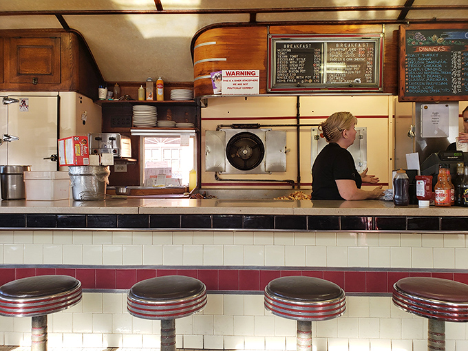 The vintage counter with its classic swivel stools invites you to sit, sip coffee, and watch the choreographed dance of short-order cooking.