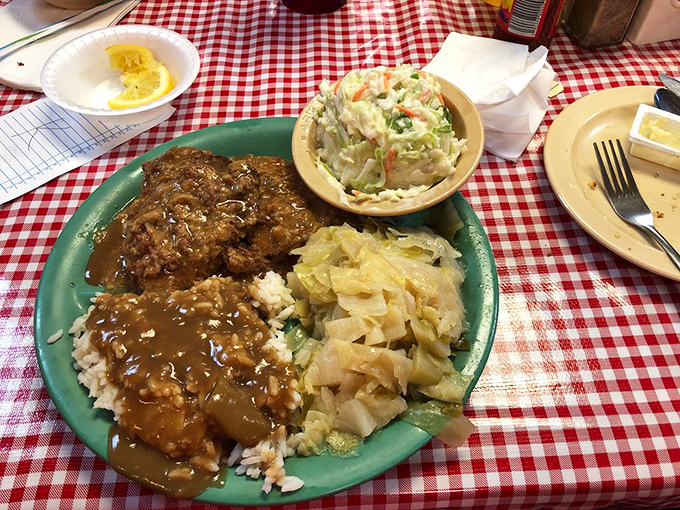 Country fried steak smothered in gravy alongside cabbage and coleslaw&mdash;a plate that whispers "you'll need a nap after this" in the most delicious way possible.