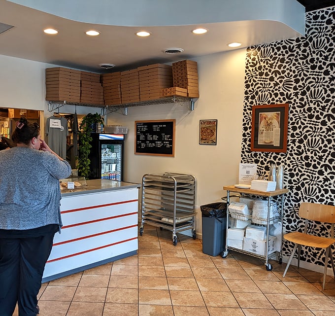 Where pizza magic happens. The ordering counter's clean design and stacked pizza boxes hint at the delicious chaos happening behind the scenes.