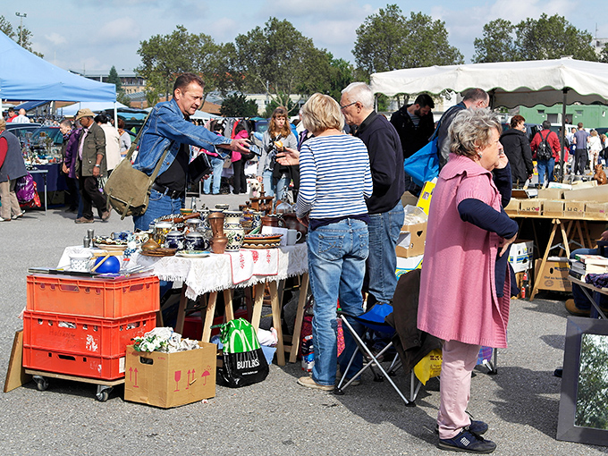 Deal-making in action! Vendors and shoppers engage in the timeless dance of negotiation&mdash;an art form that's half the fun of flea market shopping.