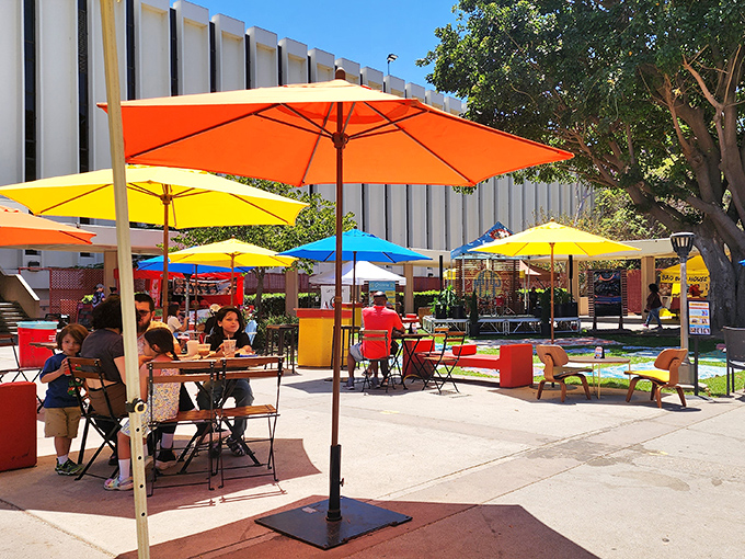Rainbow umbrellas create an oasis of shade where treasure hunters refuel and compare their finds before diving back into the market maze.