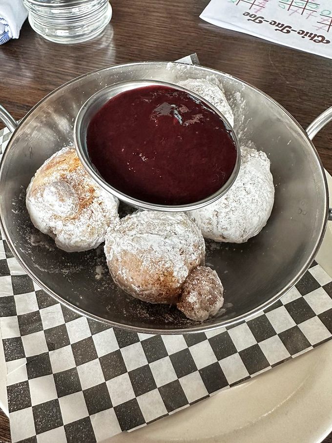 Powdered sugar donut holes with berry dipping sauce &ndash; little bites of joy that make you wonder why you'd ever waste calories on vegetables.