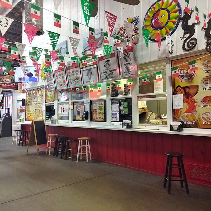Mexican food stalls festooned with colorful flags create a fiesta atmosphere. The menu board promises authentic flavors that will make your local Taco Tuesday seem like a sad imitation.