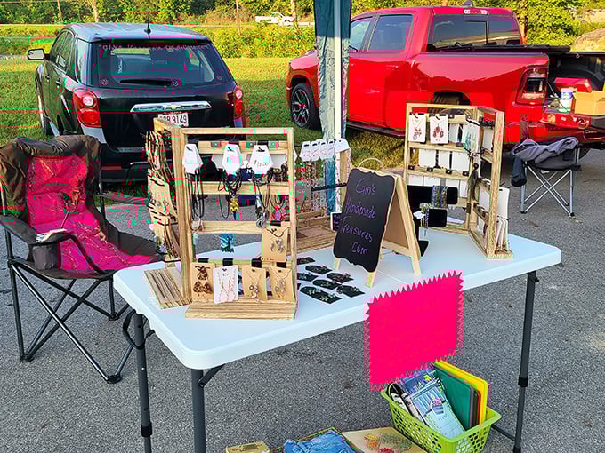 Entrepreneurial spirit in its purest form: handcrafted jewelry displayed on a folding table between parked pickup trucks.
