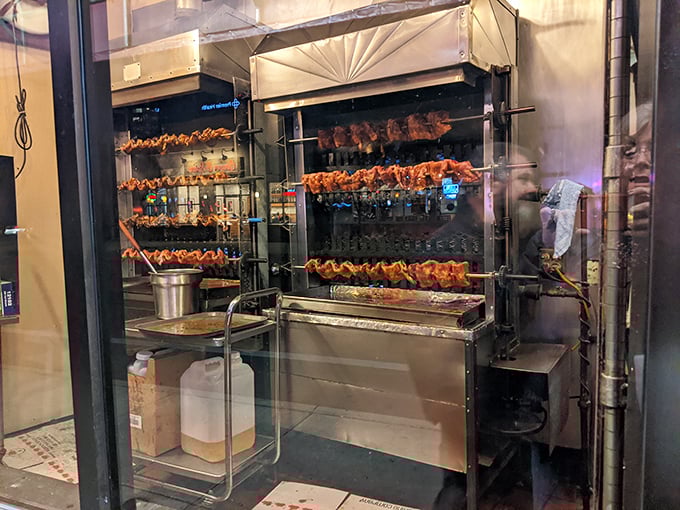 Behind glass, chickens perform their hypnotic rotisserie ballet, a window into the primal satisfaction of watching dinner slowly become delicious before your eyes.