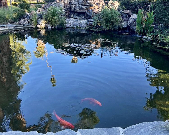 Koi fish glide through crystal waters like living jewels, adding movement and magic to the already enchanted garden landscape.