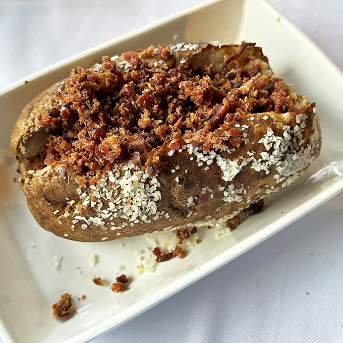 A loaded baked potato that's dressed for its own red carpet event, wearing bacon bits like sequins and sour cream like a designer accessory.