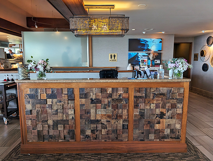 The reception area doesn't just welcome&mdash;it sets expectations with its textured wood mosaic front, promising natural materials and thoughtful design throughout. 