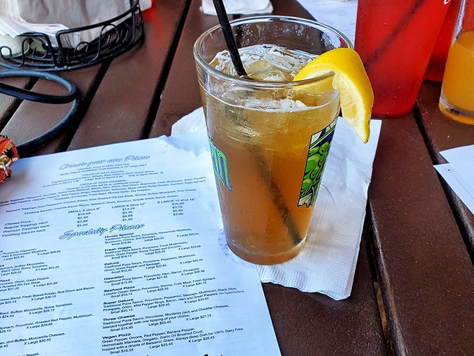 The Long Island Iced Tea sits innocently beside the menu, like a wolf in sheep's clothing, ready to turn lunch into an unexpected adventure.