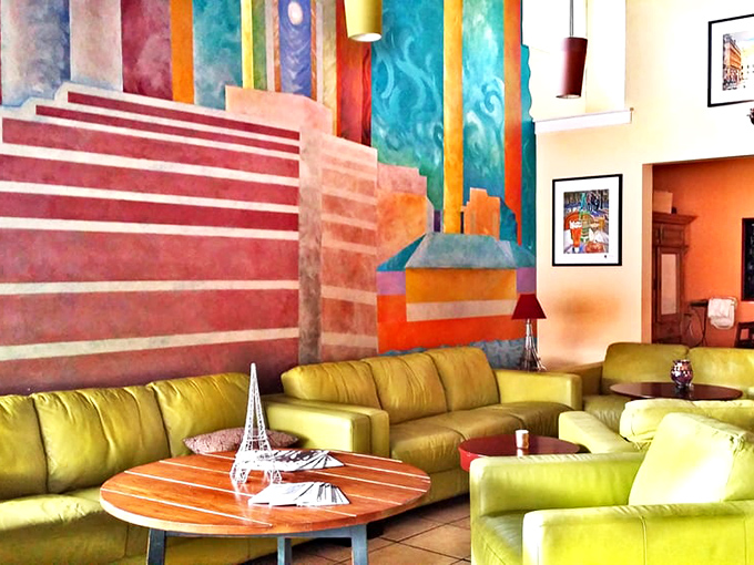 The lounge area's vibrant mural and lime-green seating create a space where even waiting for your table becomes part of the experience.