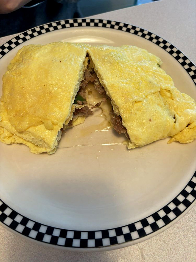 This omelet has more folds than an origami convention. A perfect golden exterior concealing savory treasures within &ndash; breakfast as it should be.