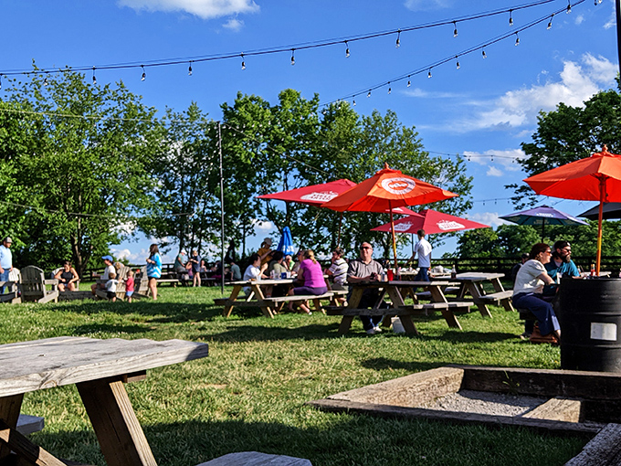 The outdoor patio buzzes with the energy of people discovering that food tastes better under Kentucky sky, with string lights adding magic as dusk falls.