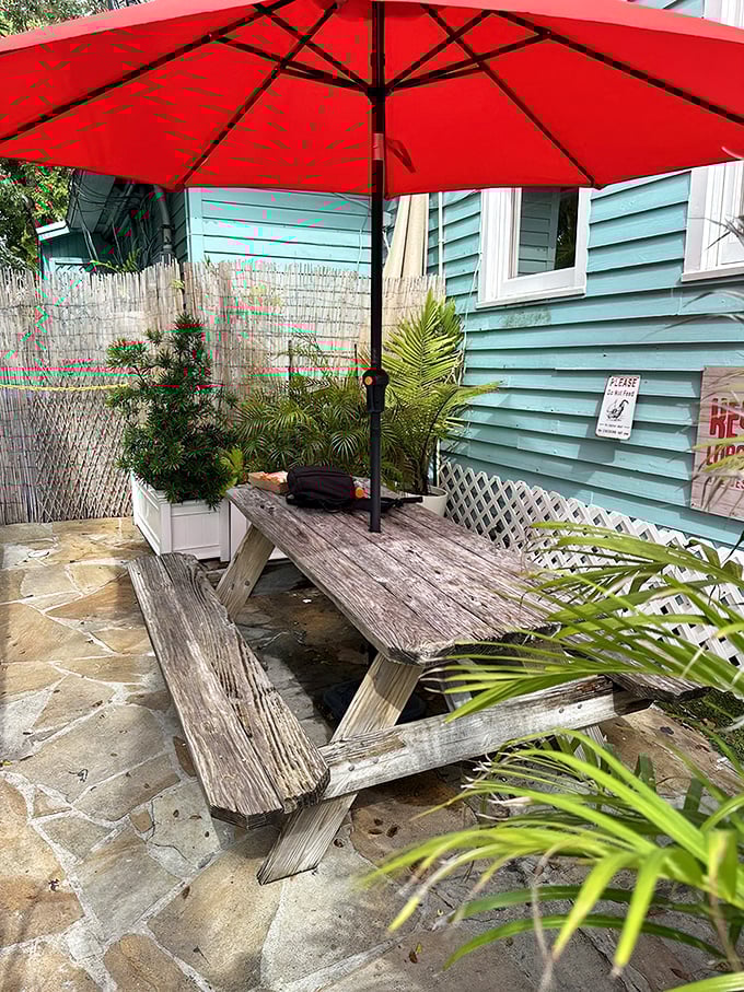 Outdoor dining, Florida style. This weathered picnic table under a cherry-red umbrella is where memories are made between bites of perfection.